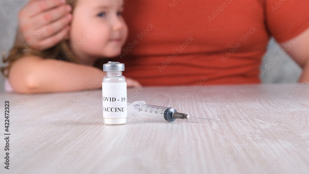 Little girl in the doctors office vaccinated. Syringe with vaccine ...