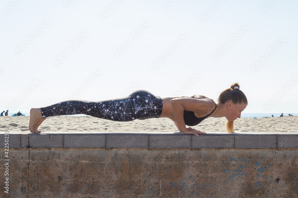 A former dancer woman does yoga on the beach, does poses, splits, L ...