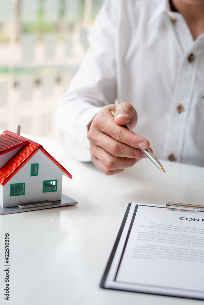A real estate broker or insurance agent works with home models and home ...