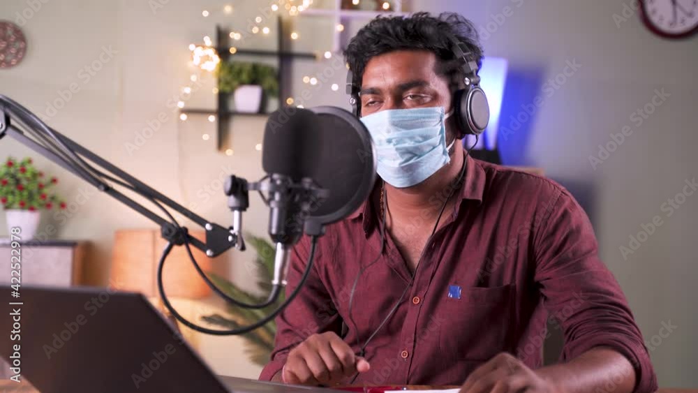 Pan shot of podcaster with medical face mask speaking in front of ...