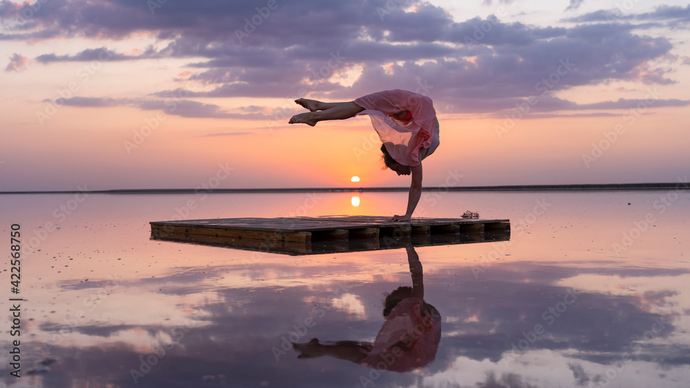 flexible woman balancing her hands in a graceful equilibrium pose ...