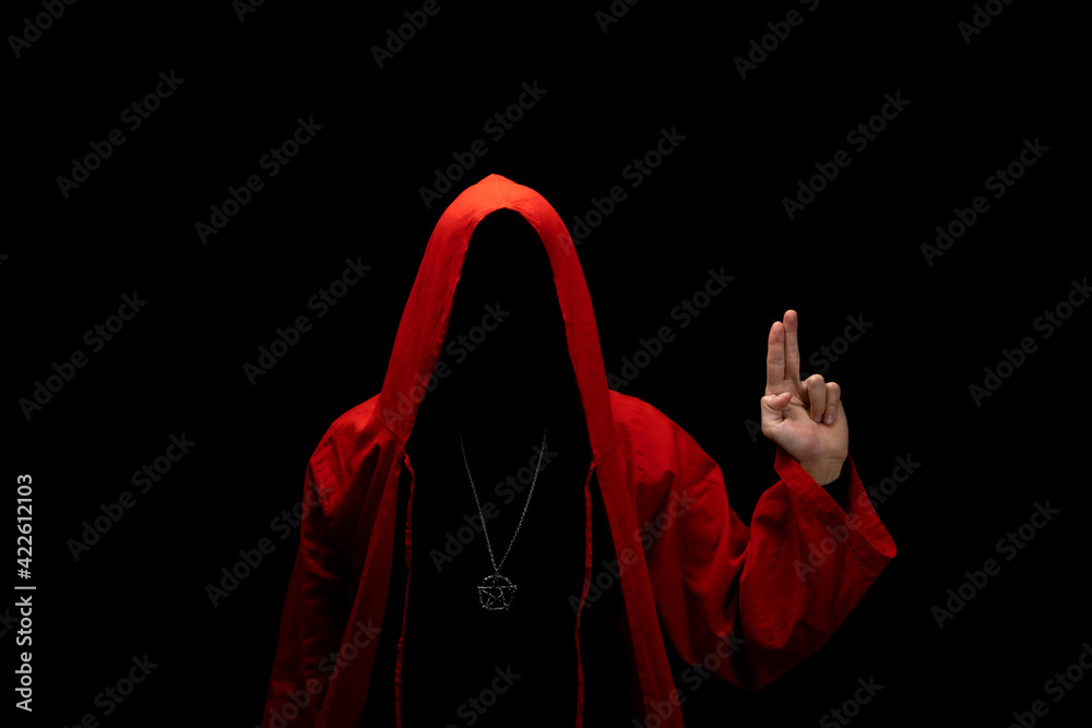 Mystery man in a red hooded cloak in the dark. Unrecognizable person. Hiding face in shadow ...