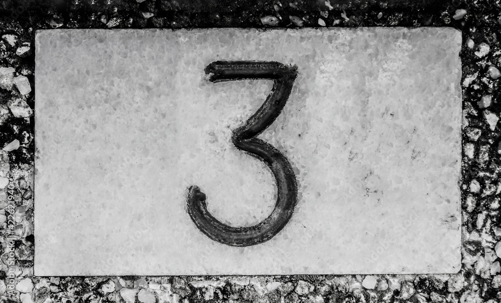 Close up outdoor view of number three 3 written in white on a black and ...