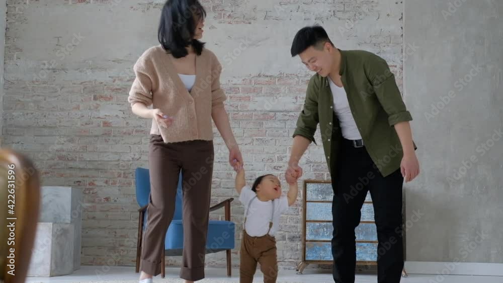 First step. first step. Loving young parents hold hands of an innocent ...