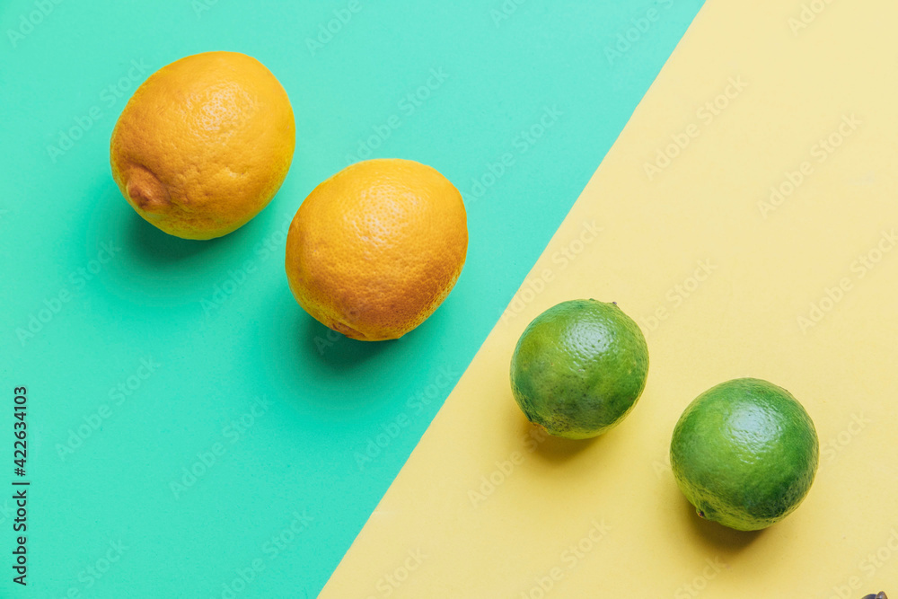 Two lemons and two limes in parallel interspersed on a green and yellow ...