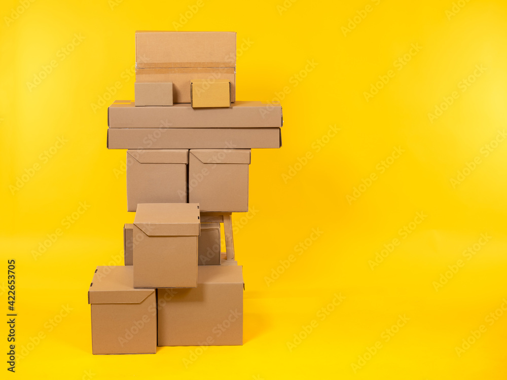 Boxes of different sizes are stacked. Cardboard boxes on a yellow ...