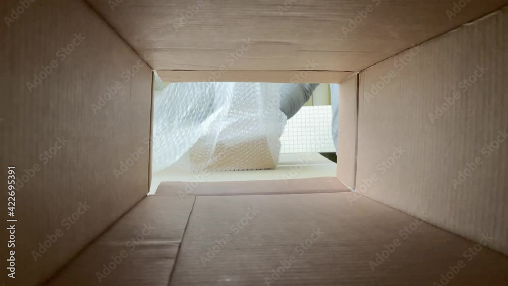 the man is packing the goods in a box. video out of the box. packing ...
