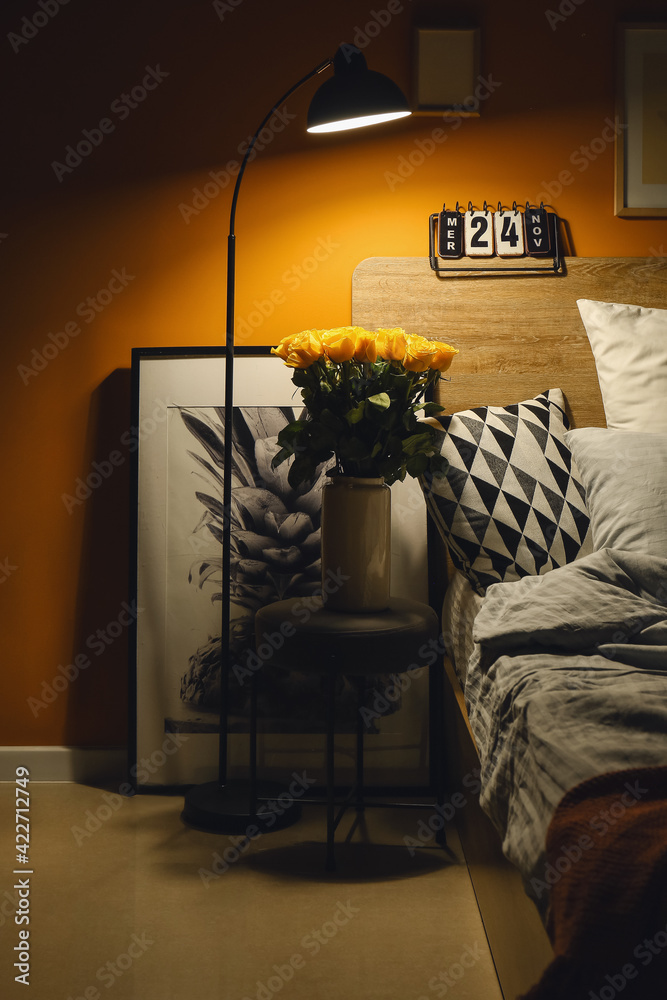 Vase with beautiful yellow roses in interior of bedroom at night Stock ...