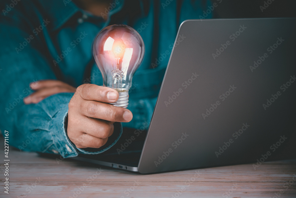 Business hand holding light bulb technology notebook, creative new idea ...