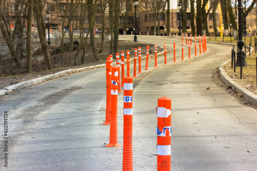 A line of flexible safety PVC delineators, orange plastic road poles ...