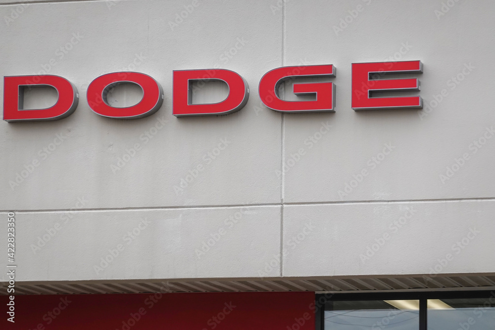The word Dodge in red letters is seen on the white exterior wall of a ...
