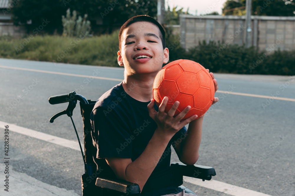 Asian special child on wheelchair is playing basket ball to strengthen ...