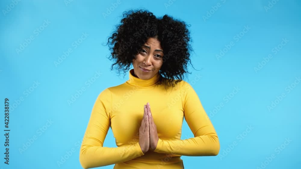 Mixed race woman praying over blue background. Afro Girl begging God to ...
