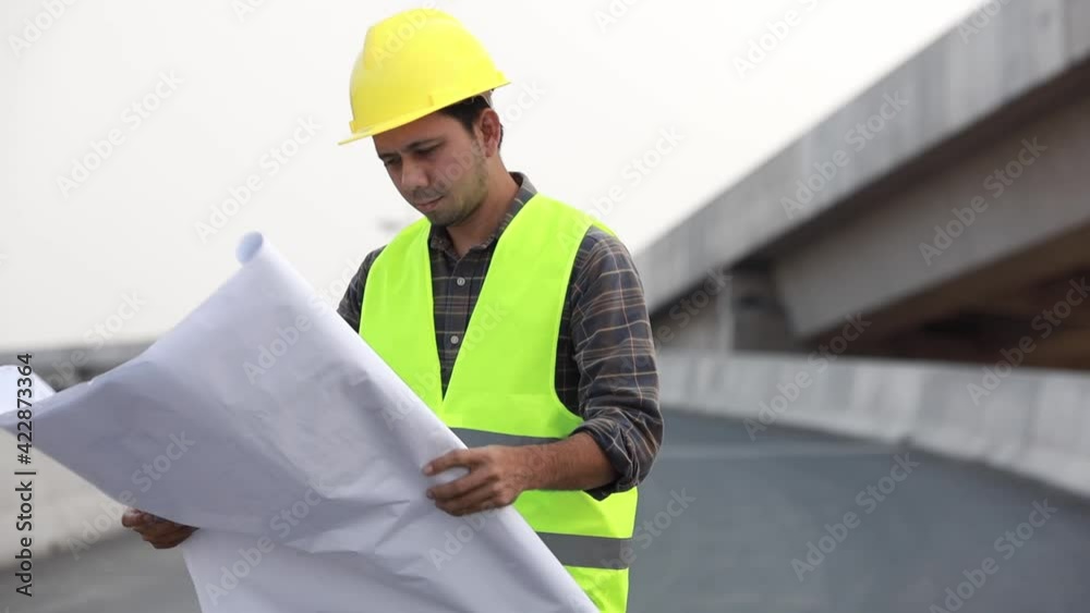 Asian construction workers check drawings plan blueprint at ...