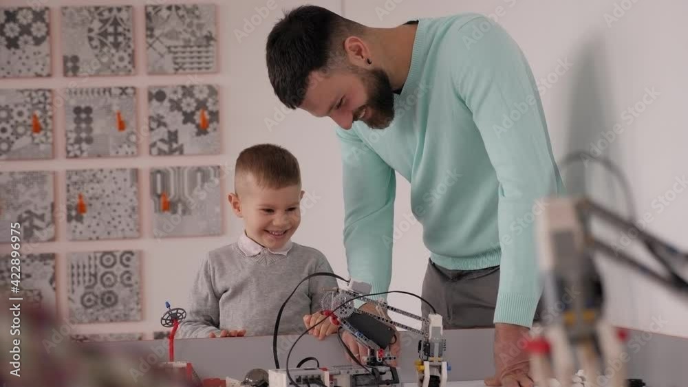 Father and son play with robots assembled from a construction in ...