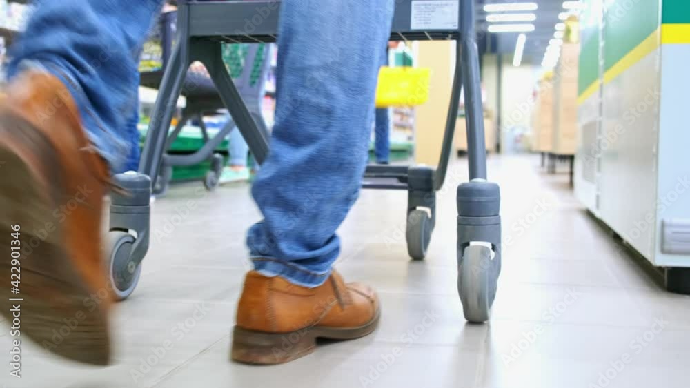 Shopping in the supermarket, view of the male legs from inside the ...