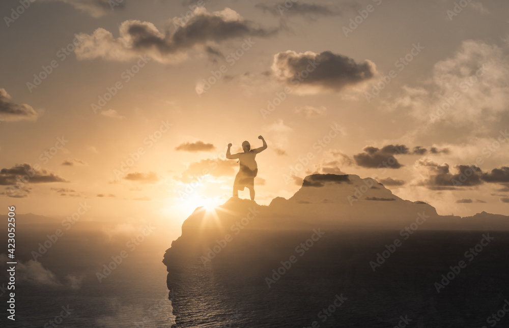 Strong man flexing on top of a mountain reaching his goals. Sport ...