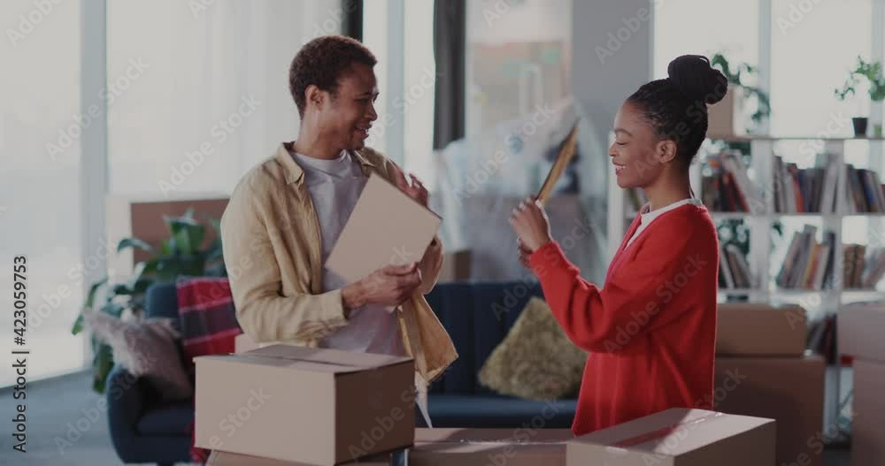 Couple of african american family moving house showing carton signs ...