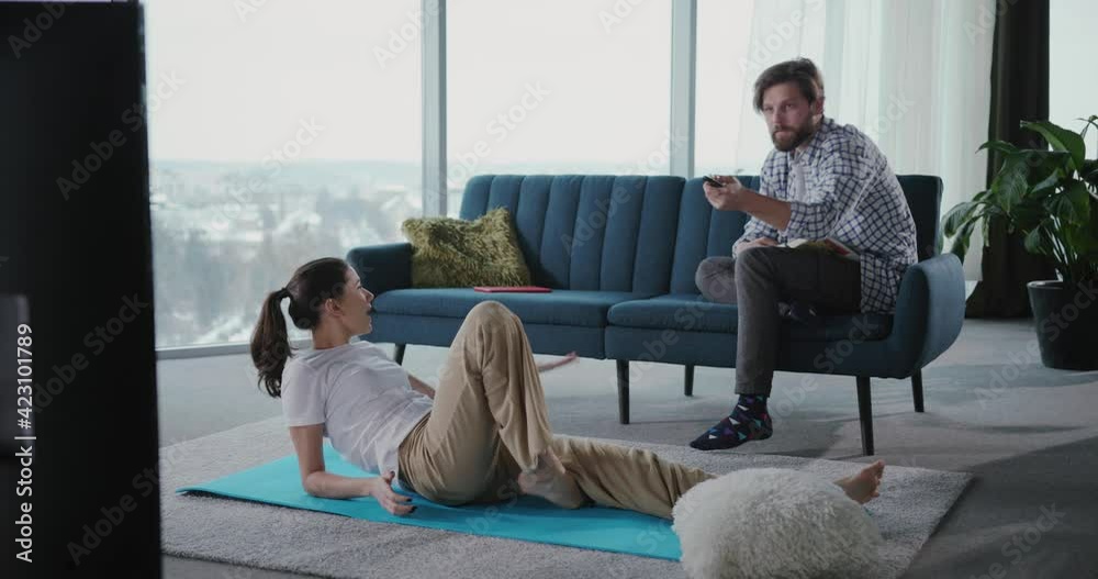 Young man turning off TV program with training exercises interrupting ...