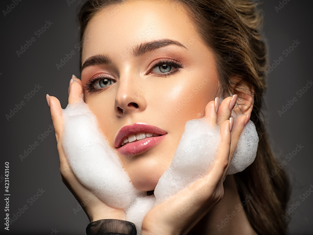 Woman with soap foam on face. Beautiful face of young caucasian woman ...
