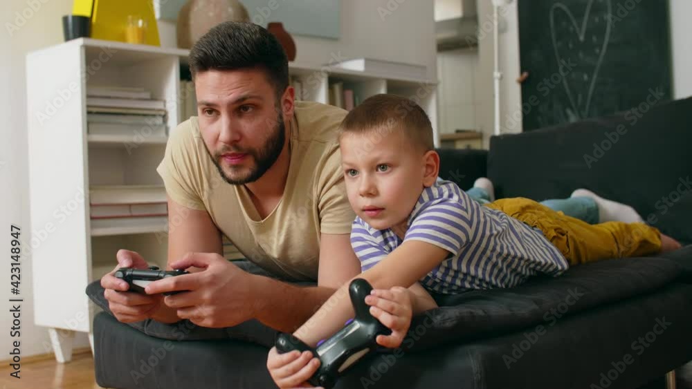 father playing video games with his son at home Stock Video | Adobe Stock