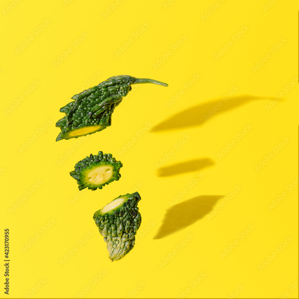 Karela cut in three pieces on bright yellow background. Stock Photo ...