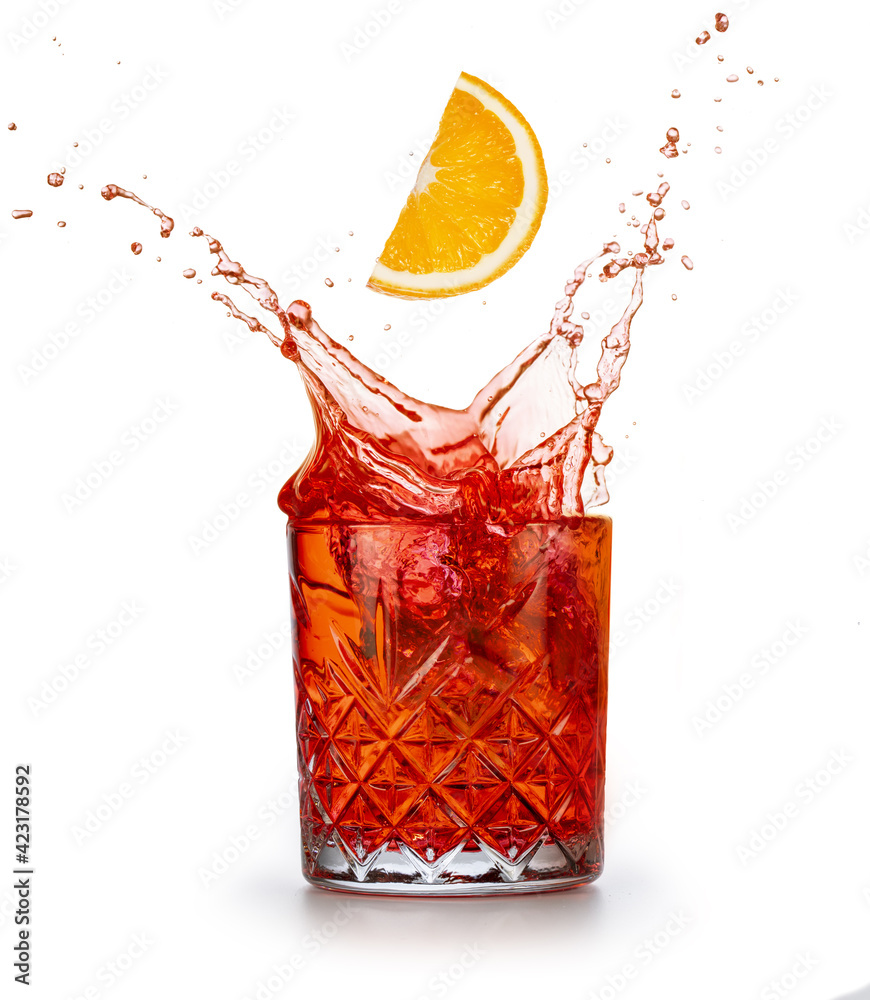 Orange slice falling in a classic Negroni Americano cocktail isolated ...