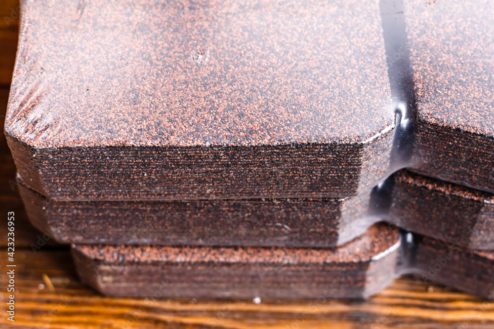 Brown bituminous shingles packed in their original packaging close-up ...
