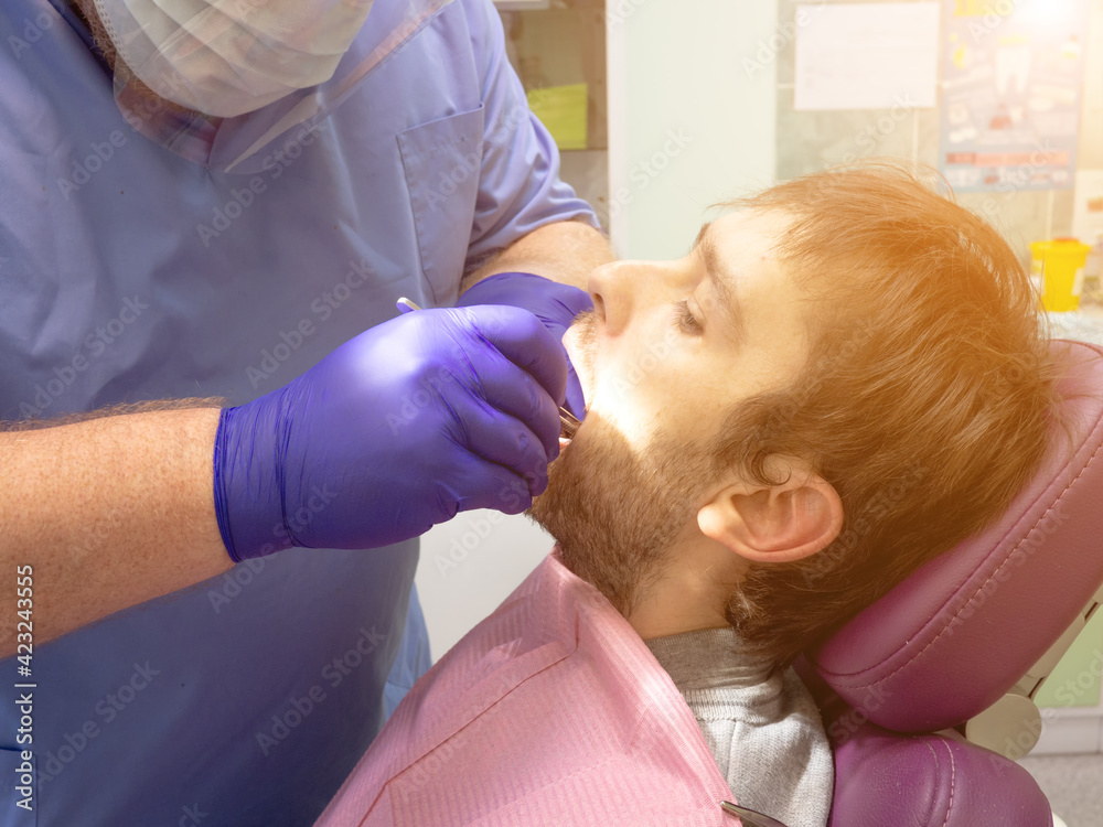 Foto de Team of dental surgeons performs surgery on teeth. in a modern ...