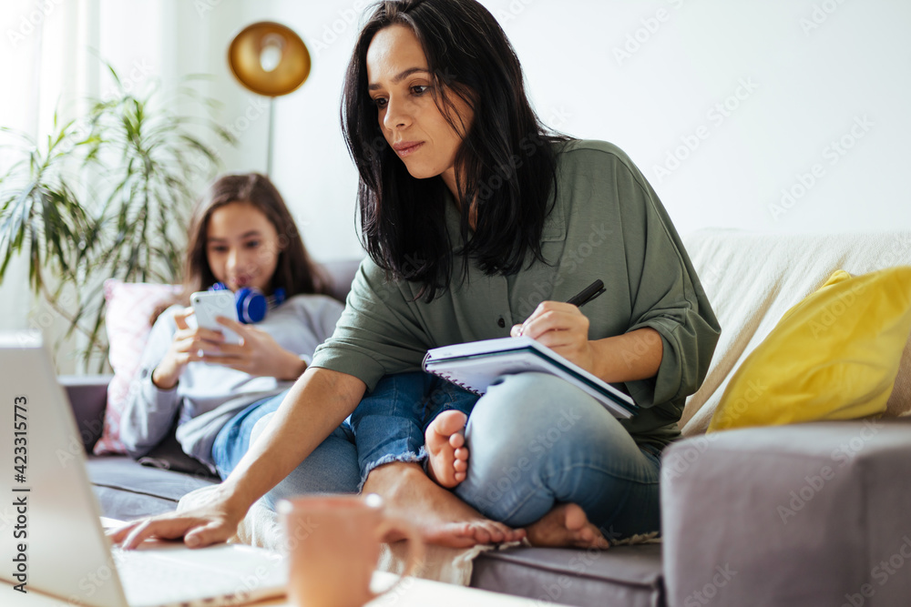 Single Mother Working From Home With Preteen Daughter Around Stock