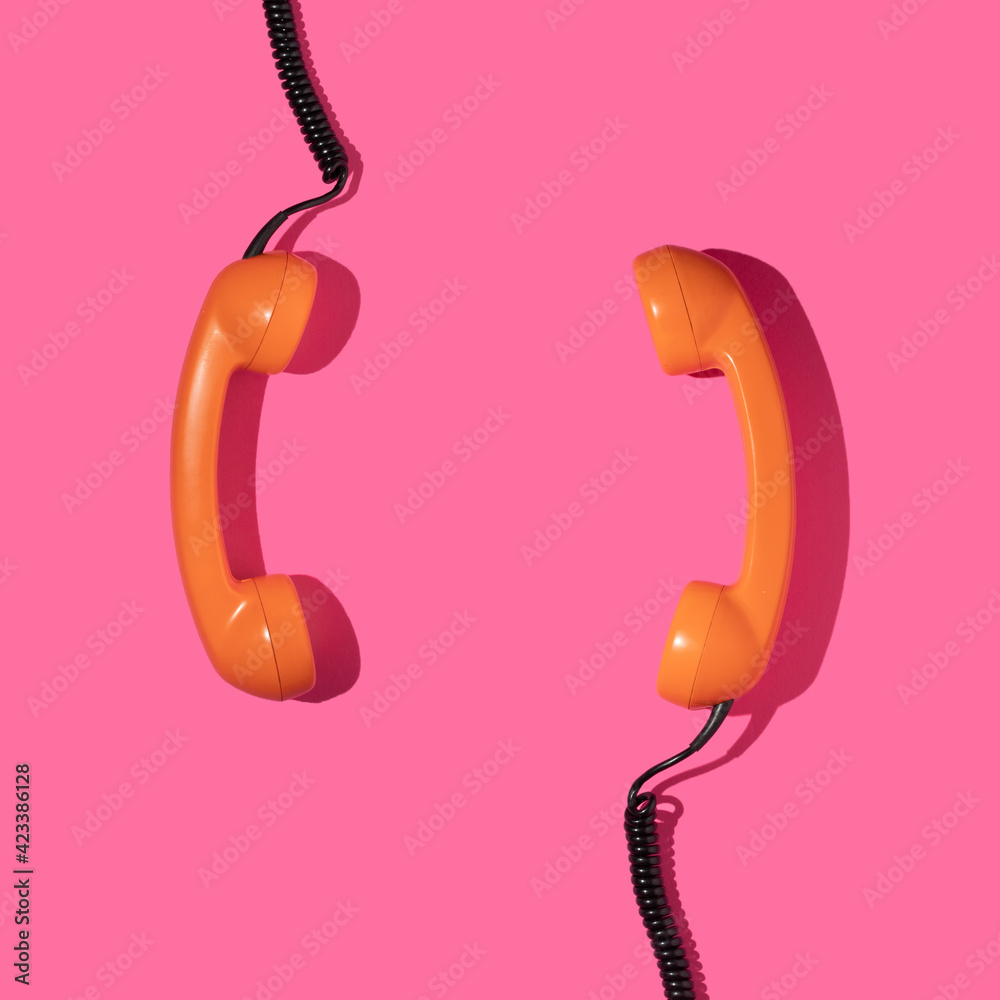 Creative layout with couple old phone handsets on bright pink ...
