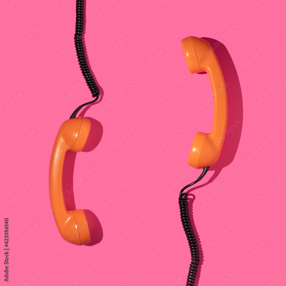 Creative layout with couple old phone handsets on bright pink ...
