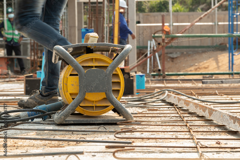 Yellow concrete vibrater on rebar for floor pouring frame in ...