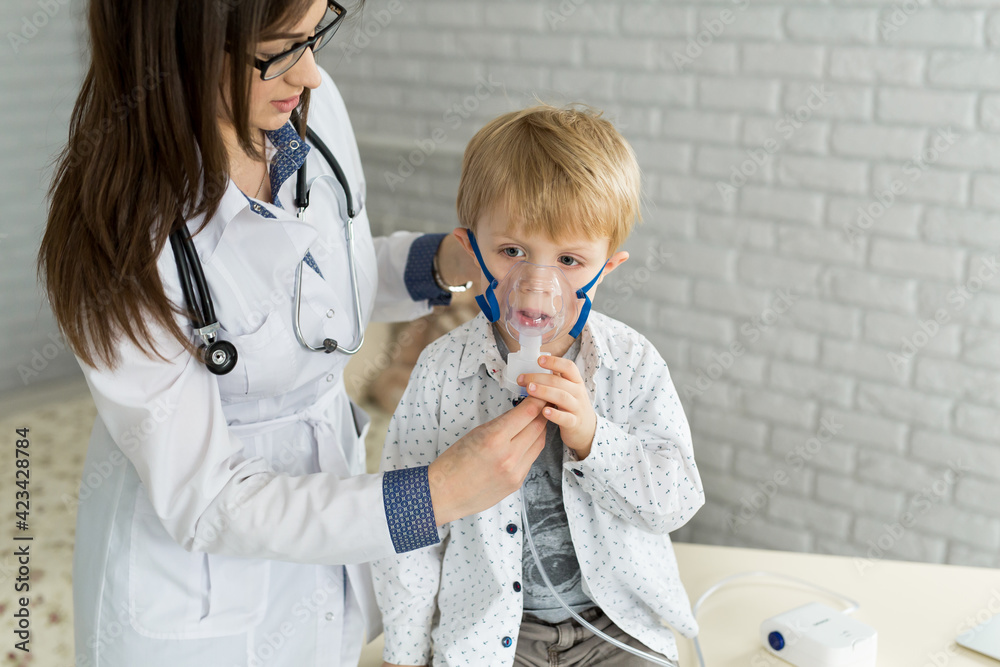 .Medical doctor applying medicine inhalation treatment on a little boy ...
