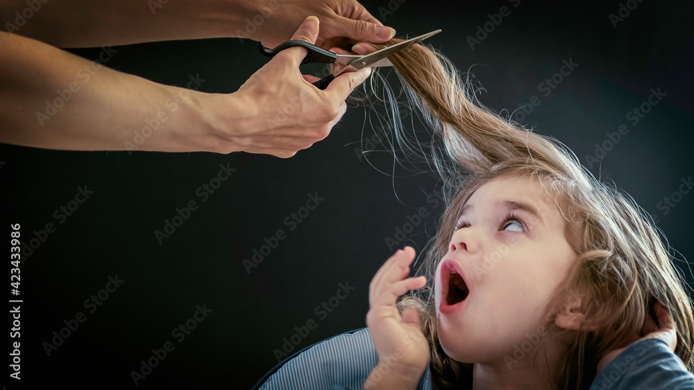 Little boy, toddler is afraid and doesn't want to cut his hair. A baby ...