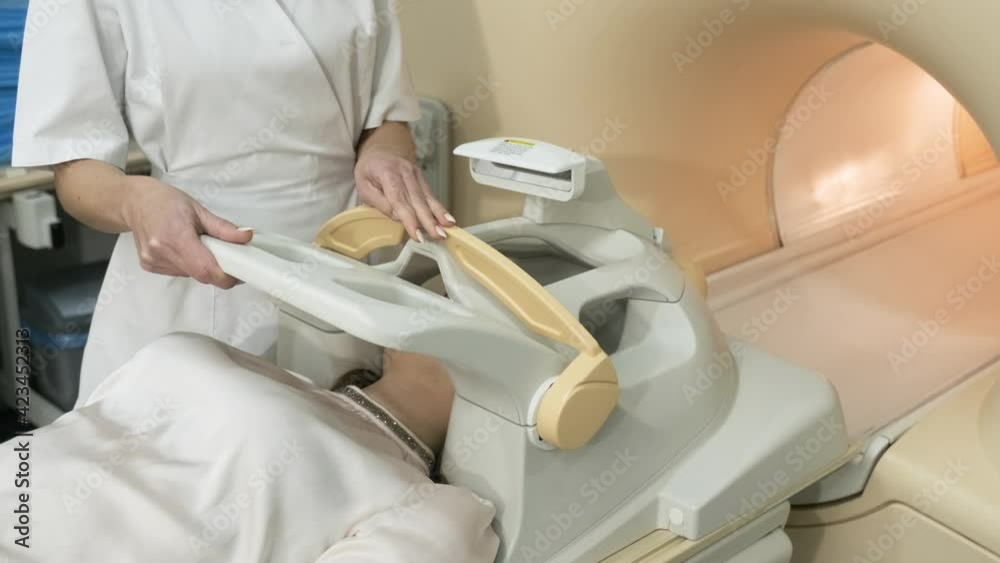 Woman doctor radiologist makes brain, head, neck MRI scanning. Young ...