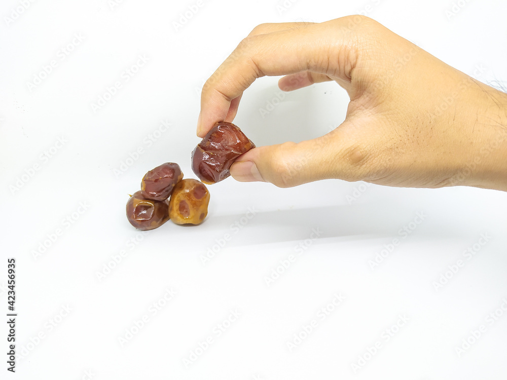 hand holding date fruit (kurma sukkari) isolated on white background ...