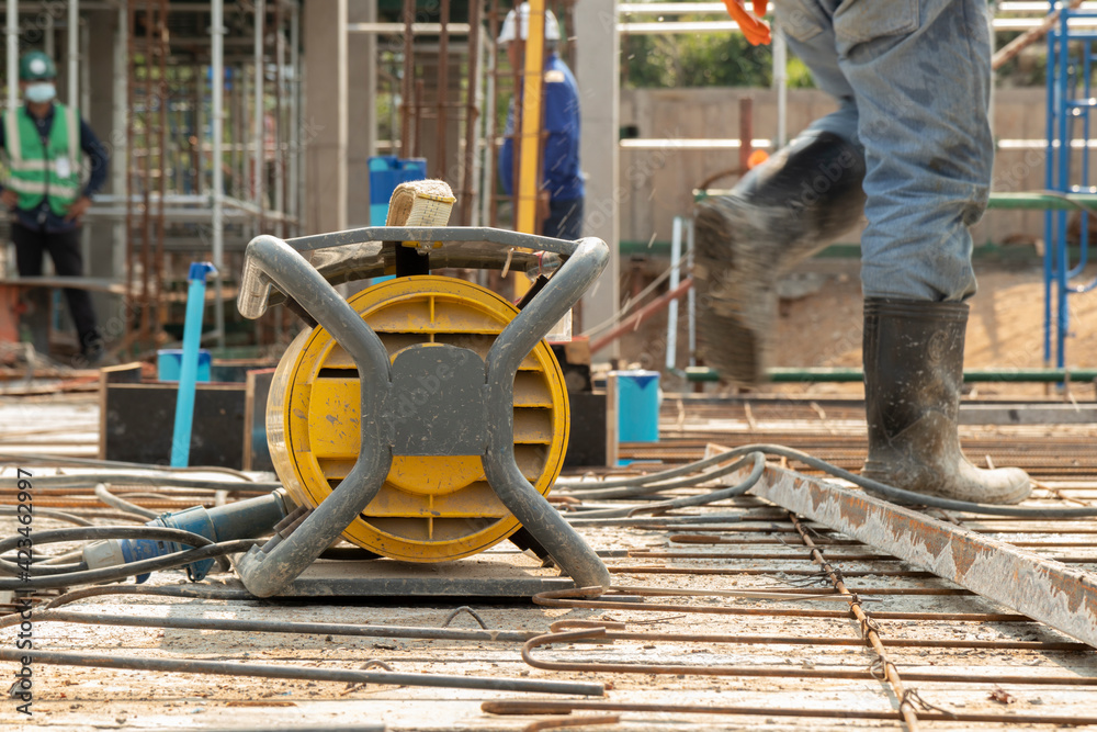 Yellow concrete vibrater on rebar for floor pouring frame in ...