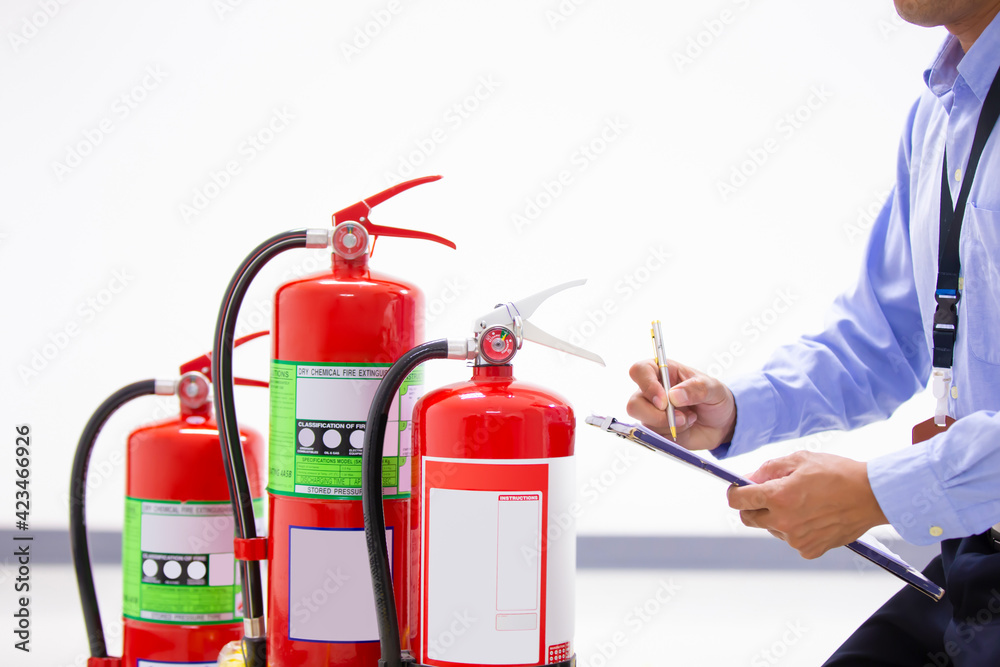 Firefighter checking pressure gauge level of fire extinguisher tank in ...