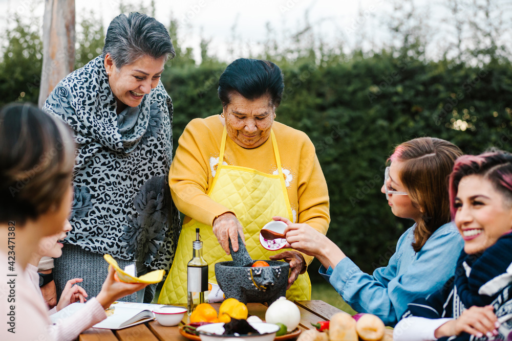 latin grandmother and granddaughter, daughter cooking mexican food at ...