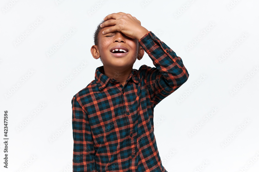 Portrait of emotional confused dark skinned little boy in checkered ...