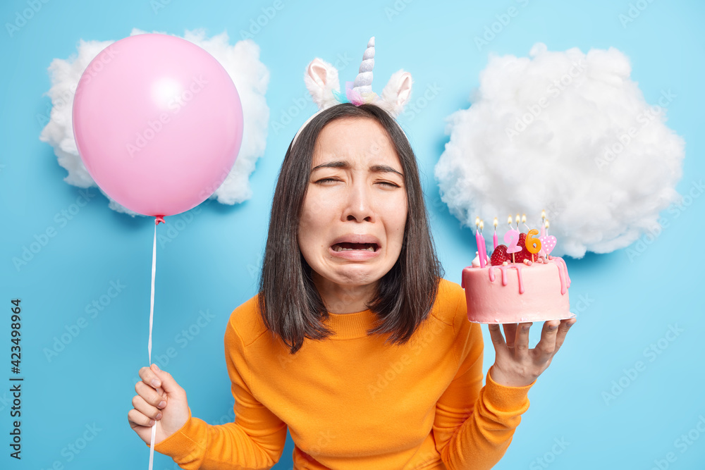 Depressed crying Asian woman feels lonely and dejected on her birthday ...