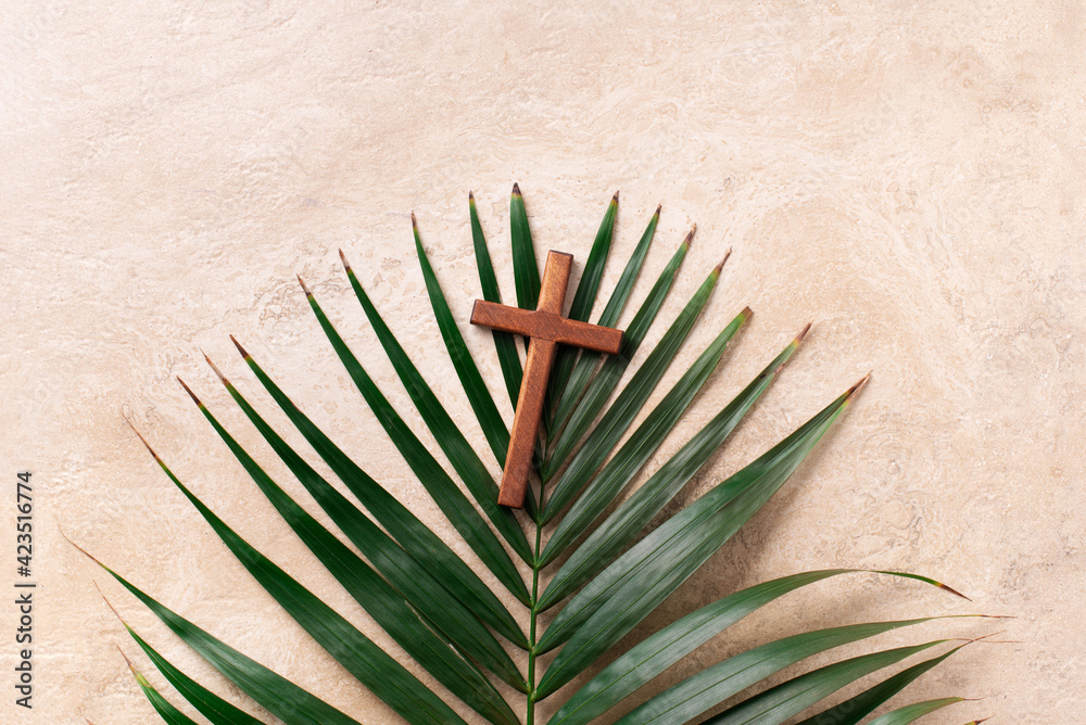 Palm Sunday concept. Wooden cross over palm leaves. Reminder of Jesus ...