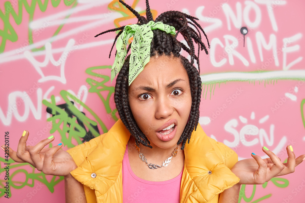 Indignant hipster girl has dreadlocks spreads palms says so what ...
