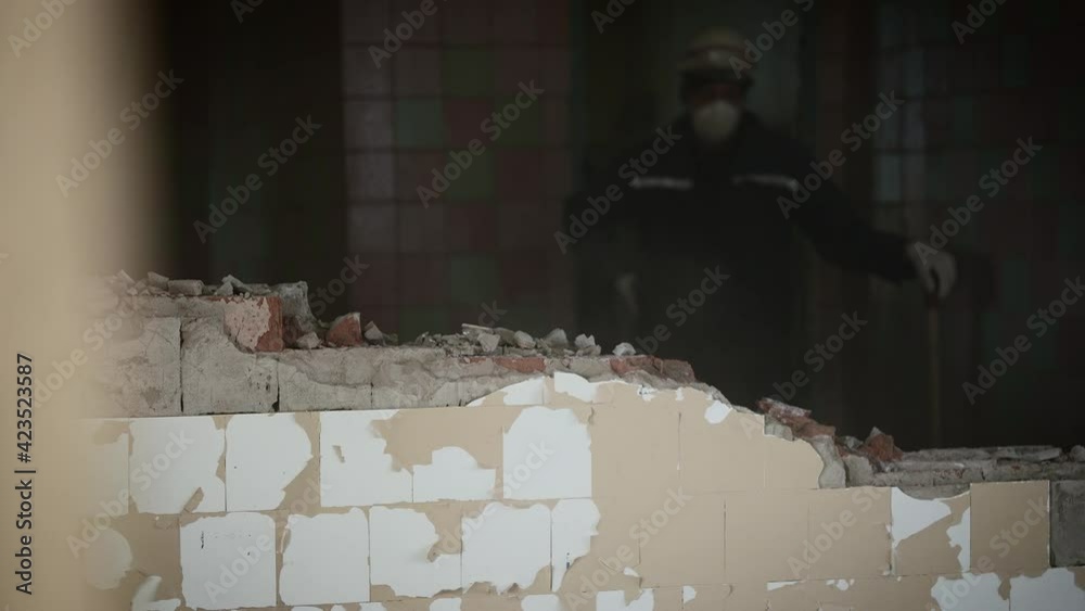 Hard male labor on a construction site. Workers demolish an unnecessary ...