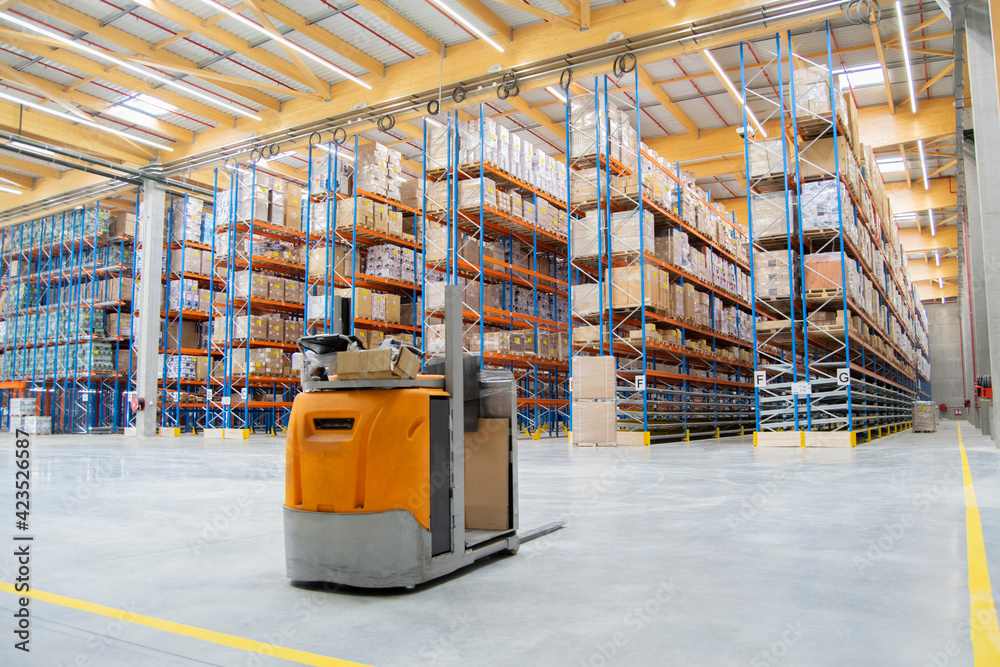 Interior view of a warehouse with racks, pallets, goods, forklifts ...