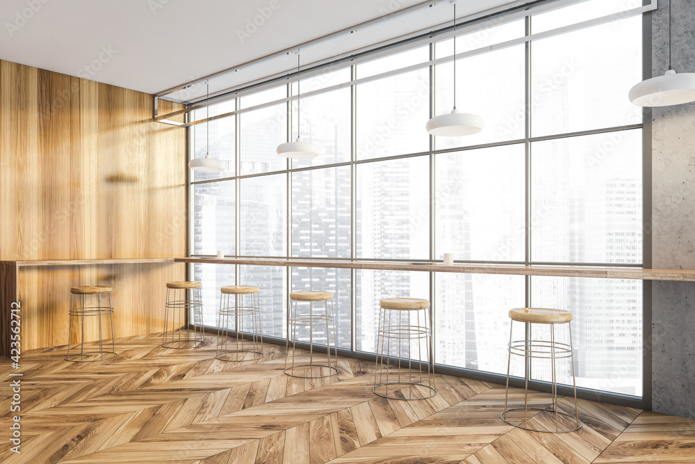 Wooden cafe interior with many seats and long table along wall and ...