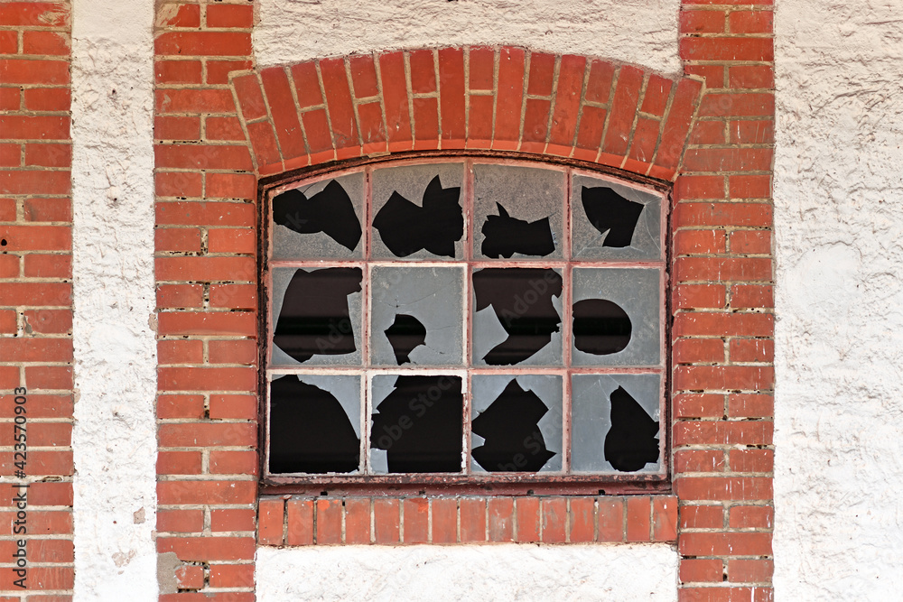 Old muntin window with broken glass of old abandoned building with red ...
