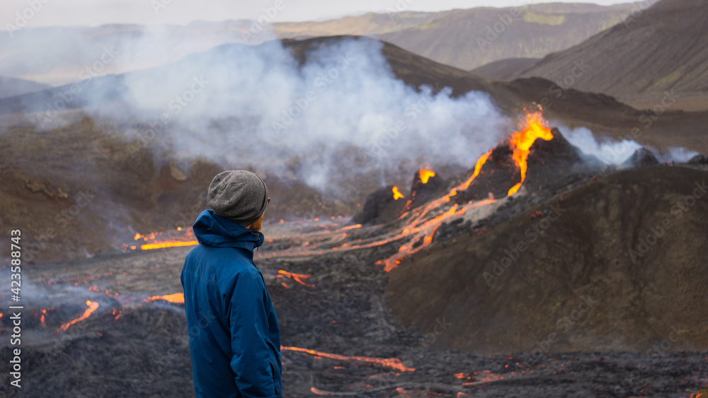 A hiker watches a small volcanic eruption in Mt Fagradalsfjall ...