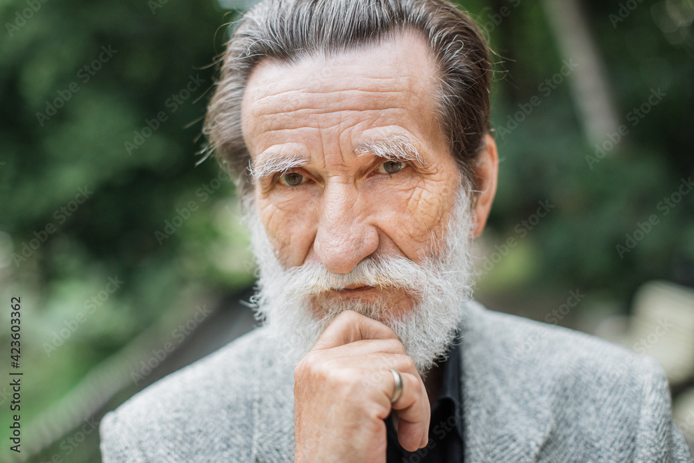 Handsome aged man in stylish clothes relaxing at green park. Caucasian ...